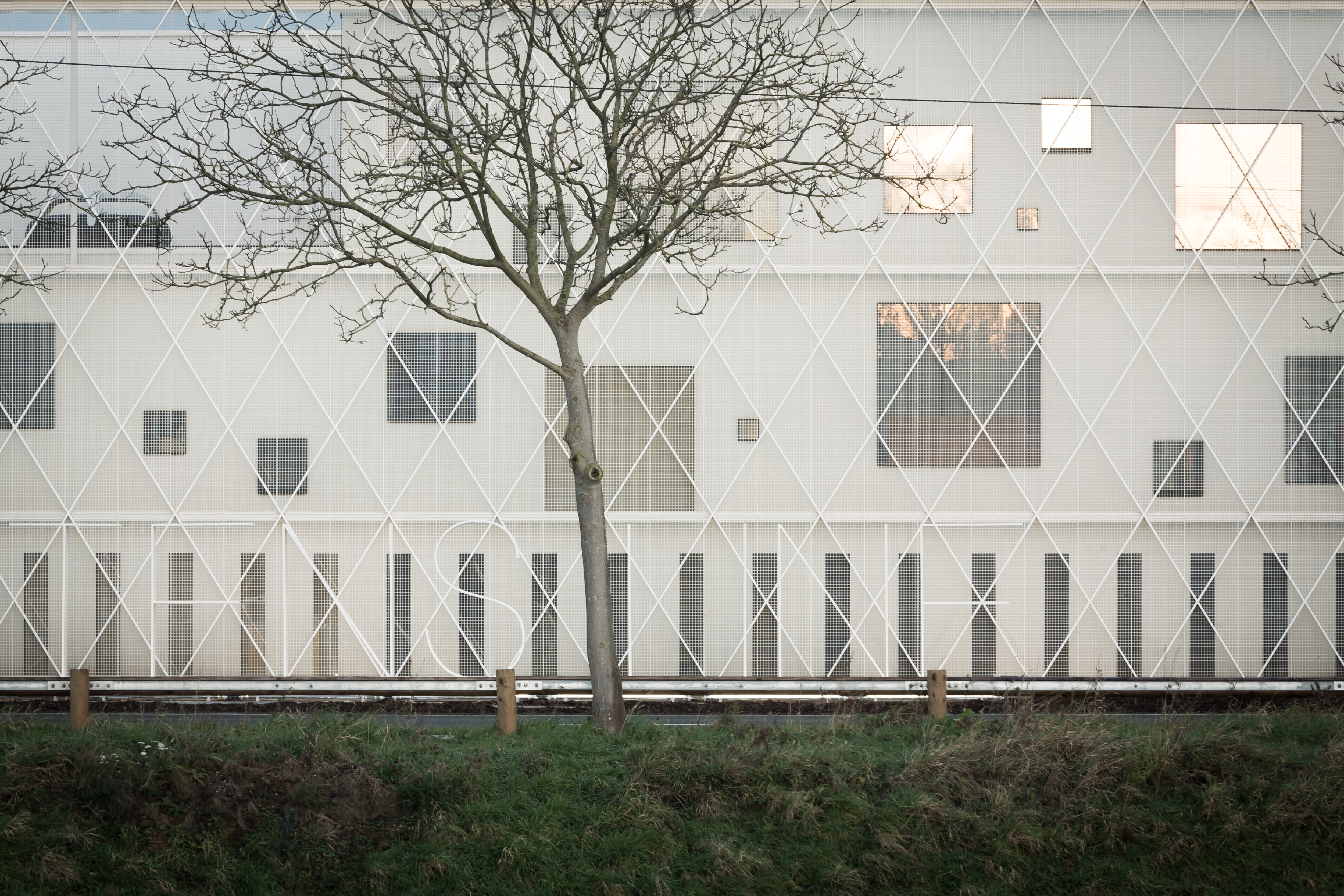 Witte roostergevel voor kantoor van staalbedrijf - architectenweb.nl