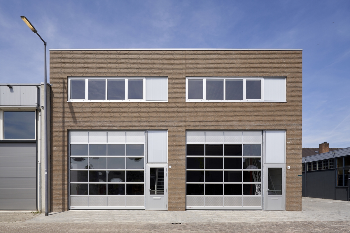Bedrijfspand met symbolische 'sheddaken' - architectenweb.nl