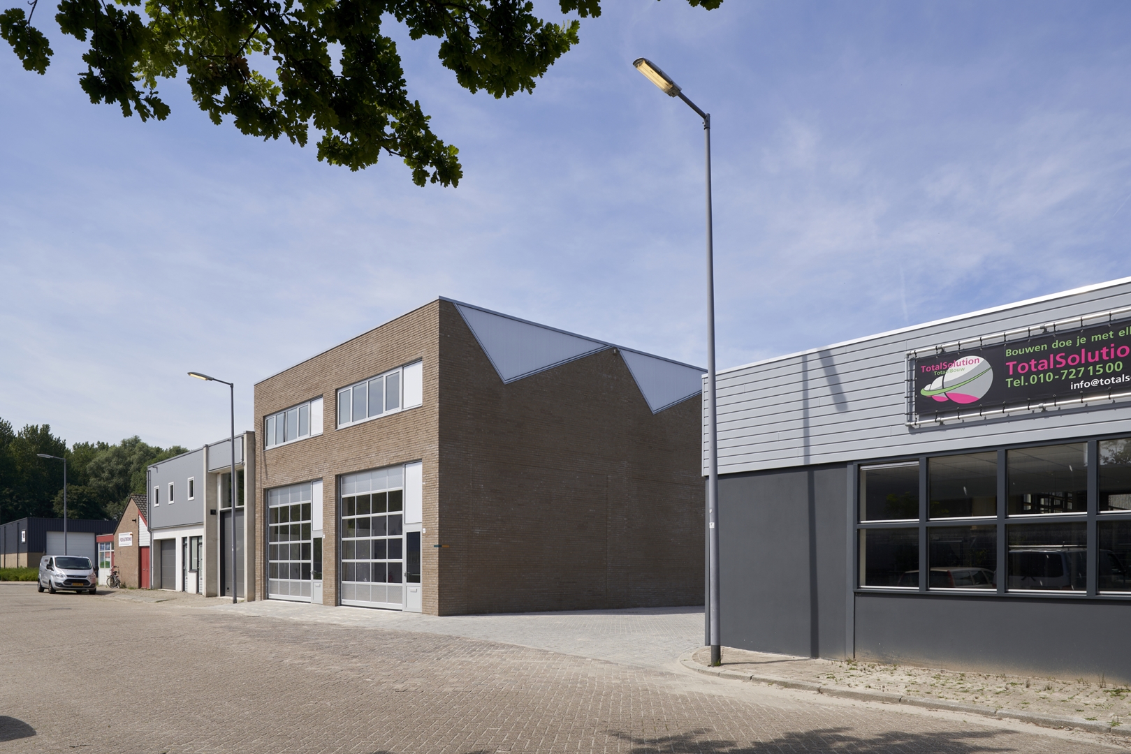 Bedrijfspand met symbolische 'sheddaken' - architectenweb.nl